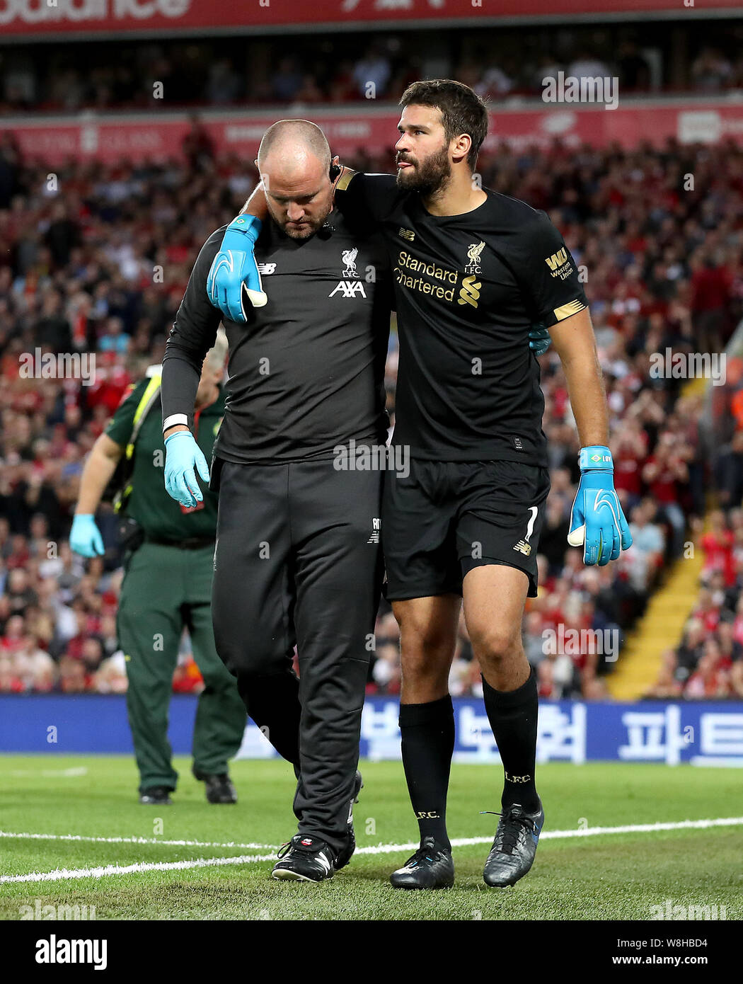 Liverpool goalkeeper Alisson (right) leaves the pitch after picking up ...