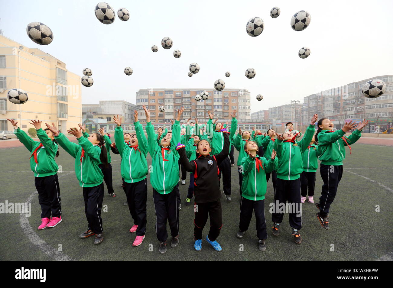 Young Chinese students throw footballs into the air during the Fourth ...