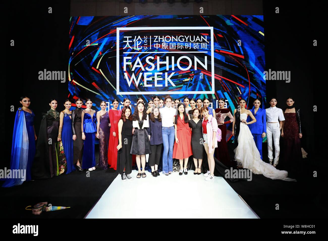 Chinese fashion designer Mary Ma, center, poses with her assistants and ...