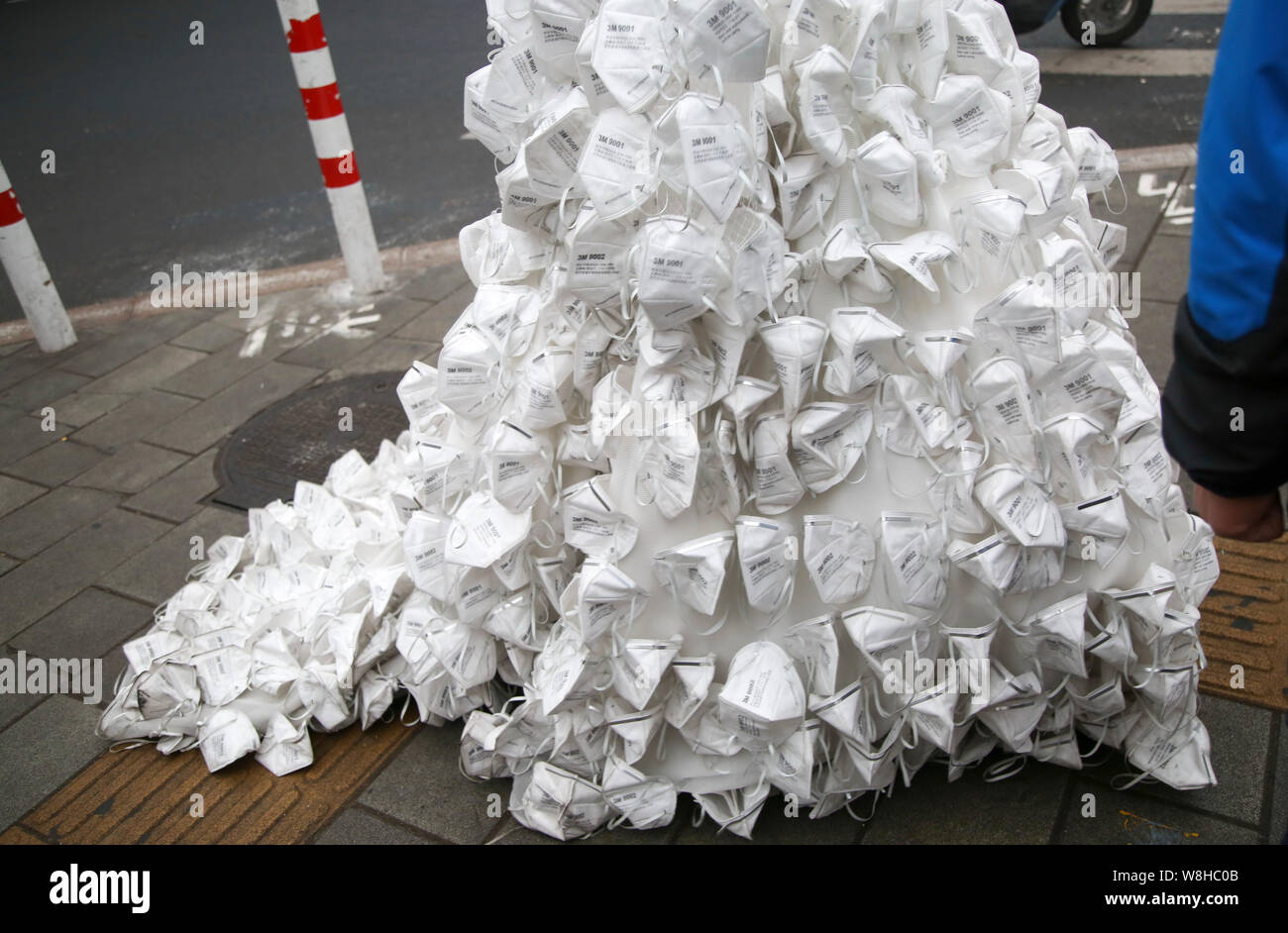 Chinese artist Kong Ning wearing a face mask and a wedding dress made ...