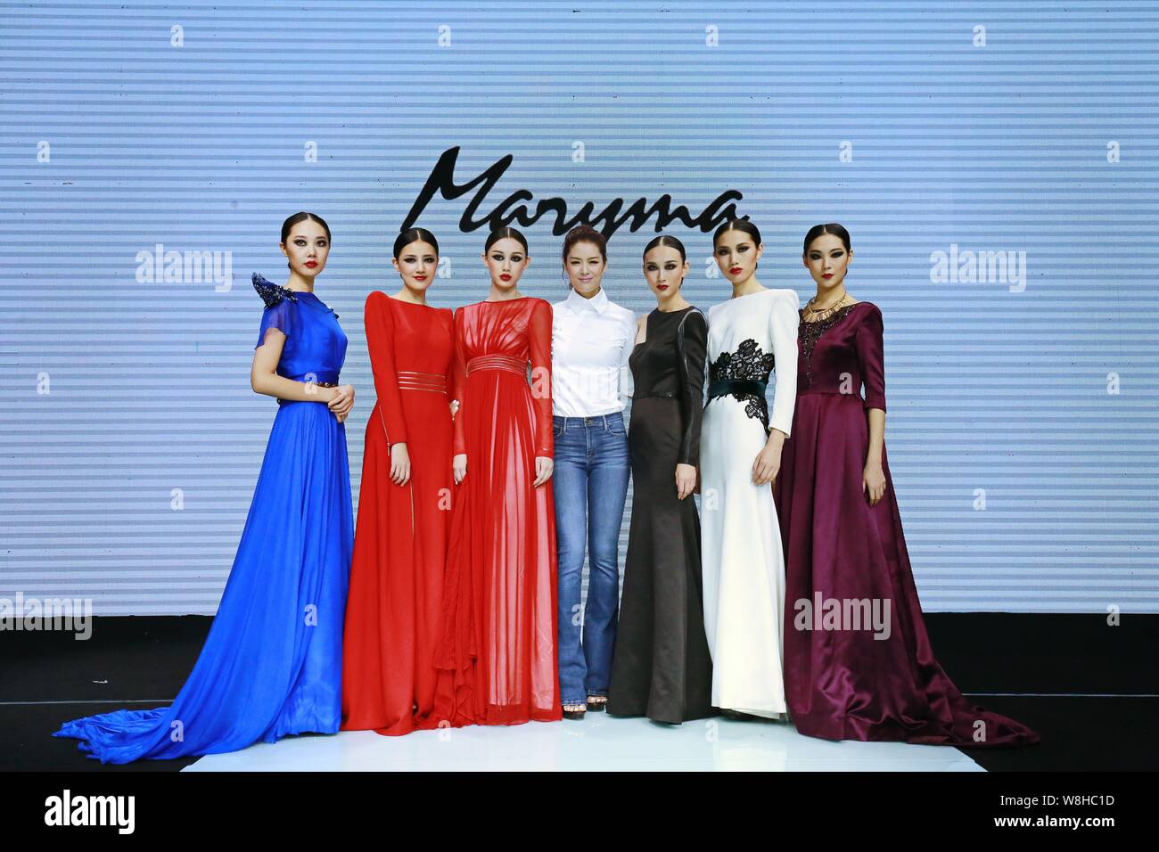 Chinese fashion designer Mary Ma, center, poses with models displaying ...