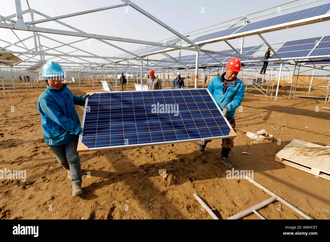 --FILE--Chinese workers install solar panels at a photovoltaic power ...