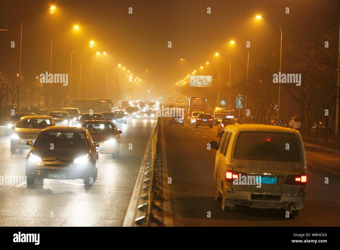 Cars and buses travel on a road in heavy smog in Beijing, China, 8 ...