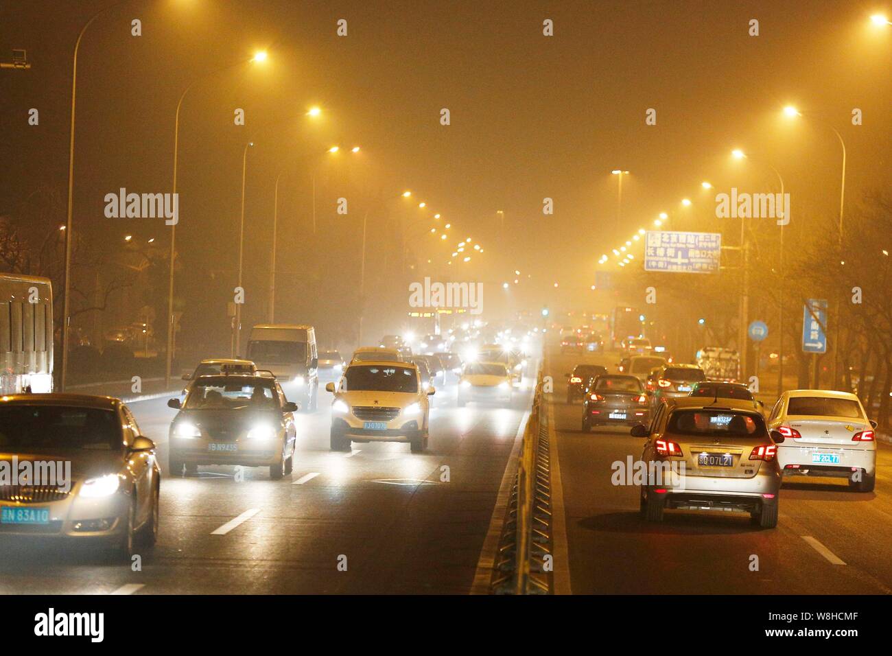 Cars travel on a road in heavy smog in Beijing, China, 8 December 2015 ...