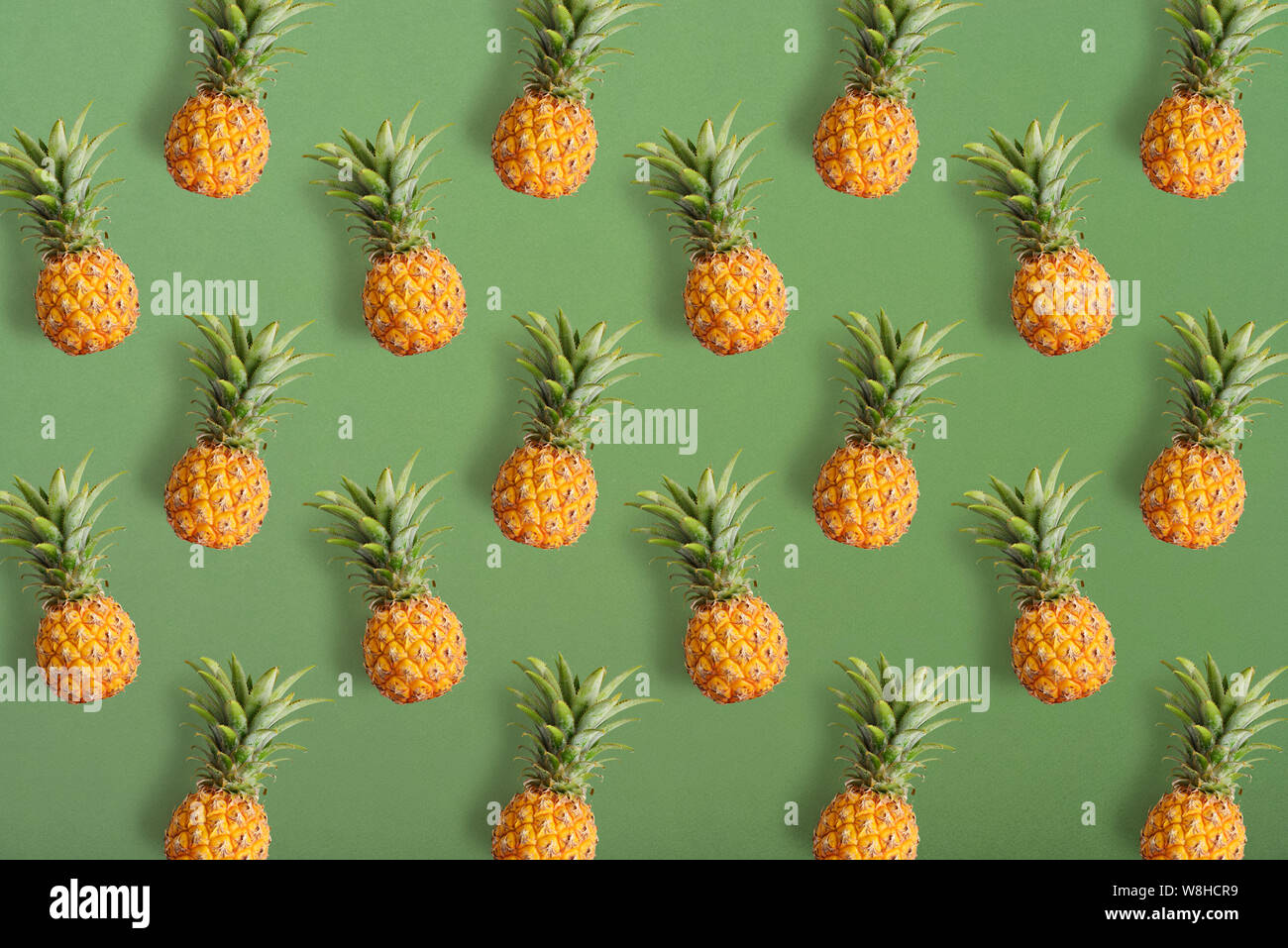 Colorful fruit pattern of fresh pineapples on green background, top ...