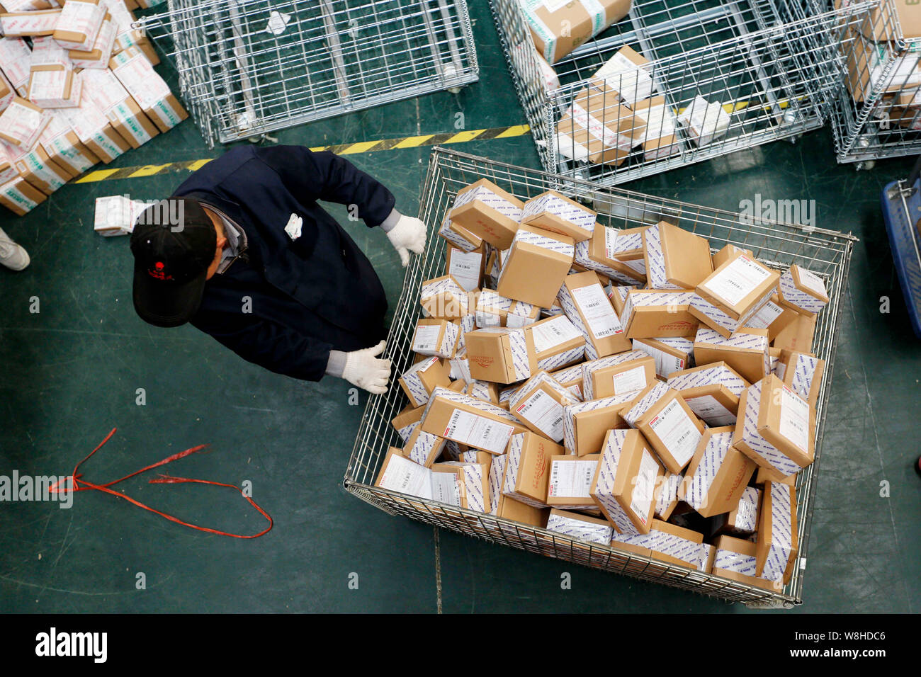 A Chinese worker carts parcels, most of which are from online shopping ...