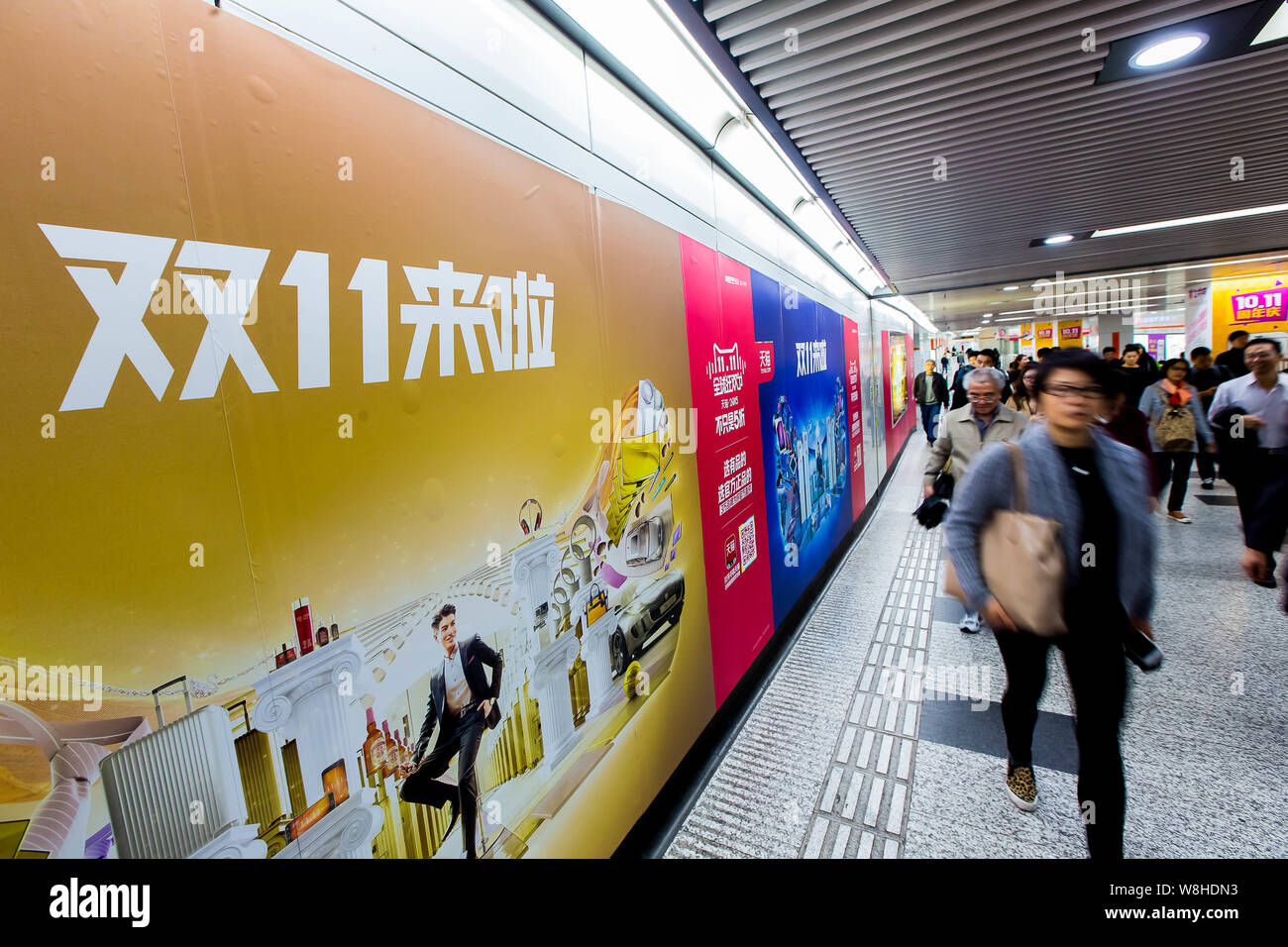 Pedestrians walk past advertisements hi-res stock photography and images - Alamy