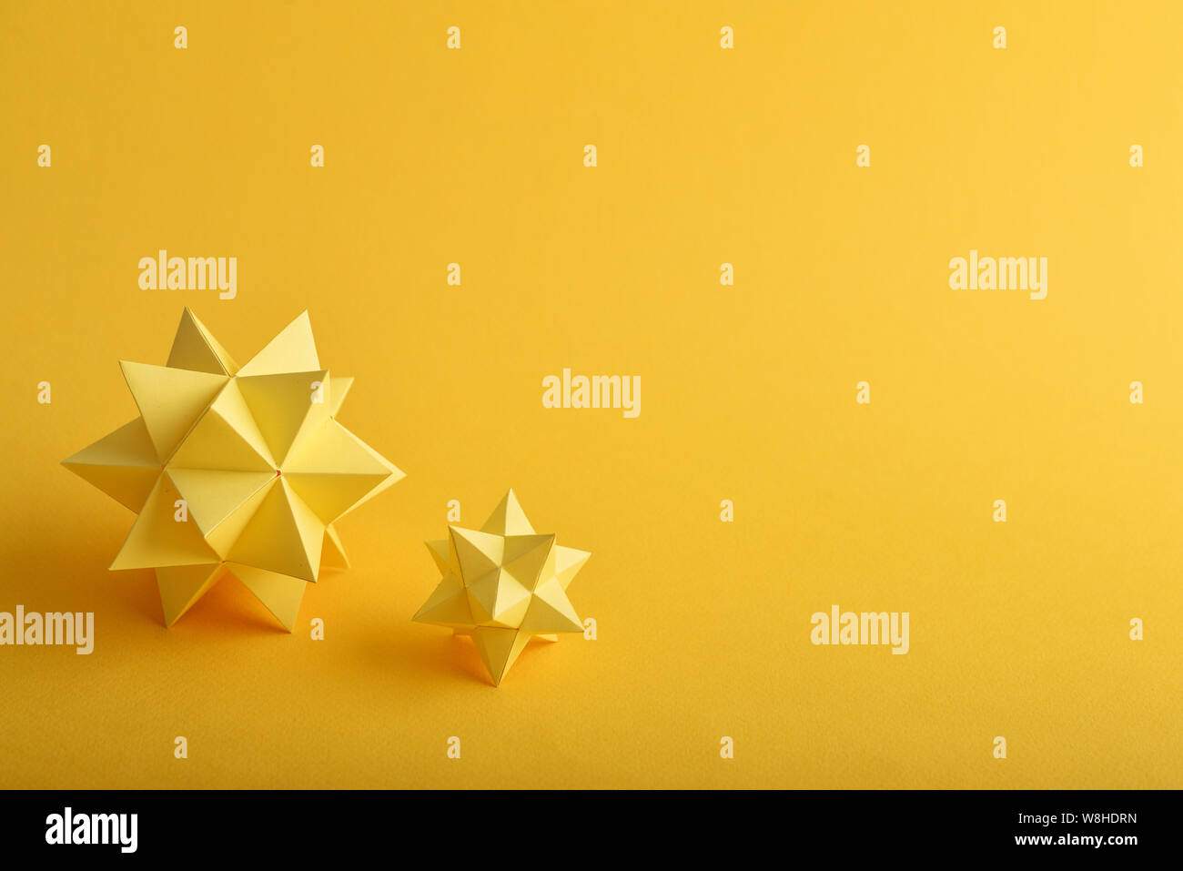 Two handmade yellow paper polyhedrons on a yellow background Stock ...