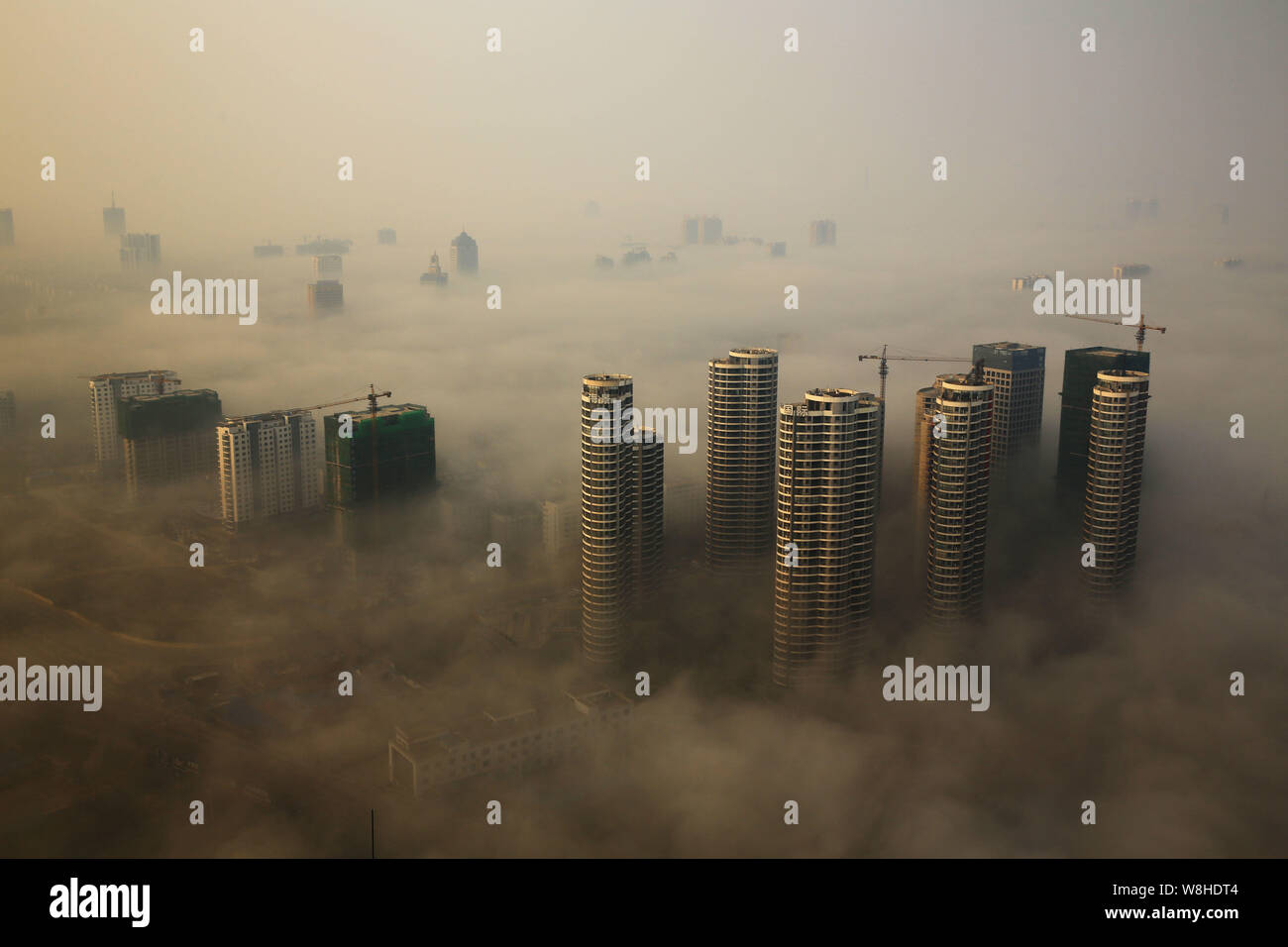 High-rise buildings are vaguely seen in heavy smog in Rizhao city, east ...
