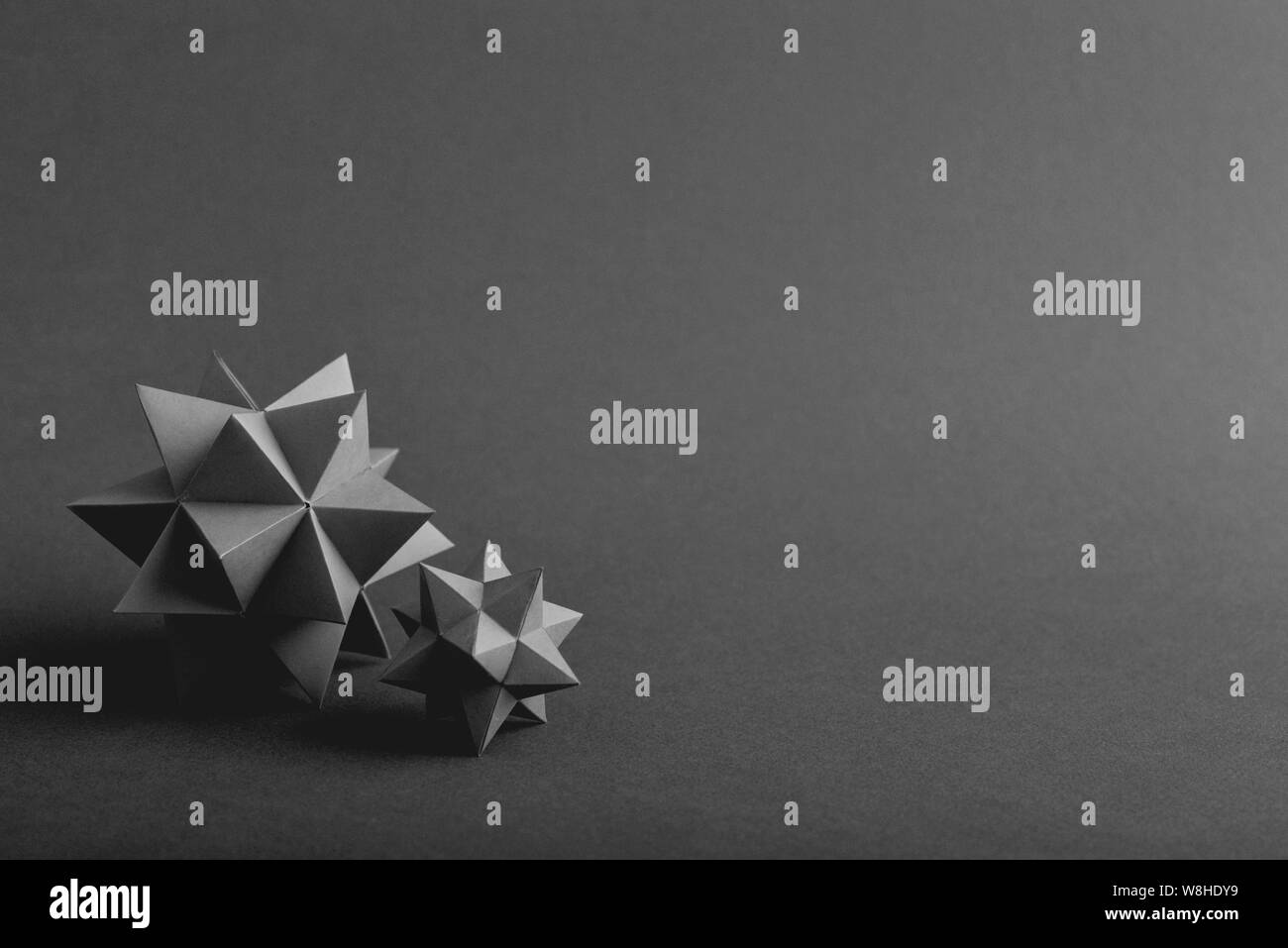 Two handmade grey paper polyhedrons on a grey background Stock Photo ...