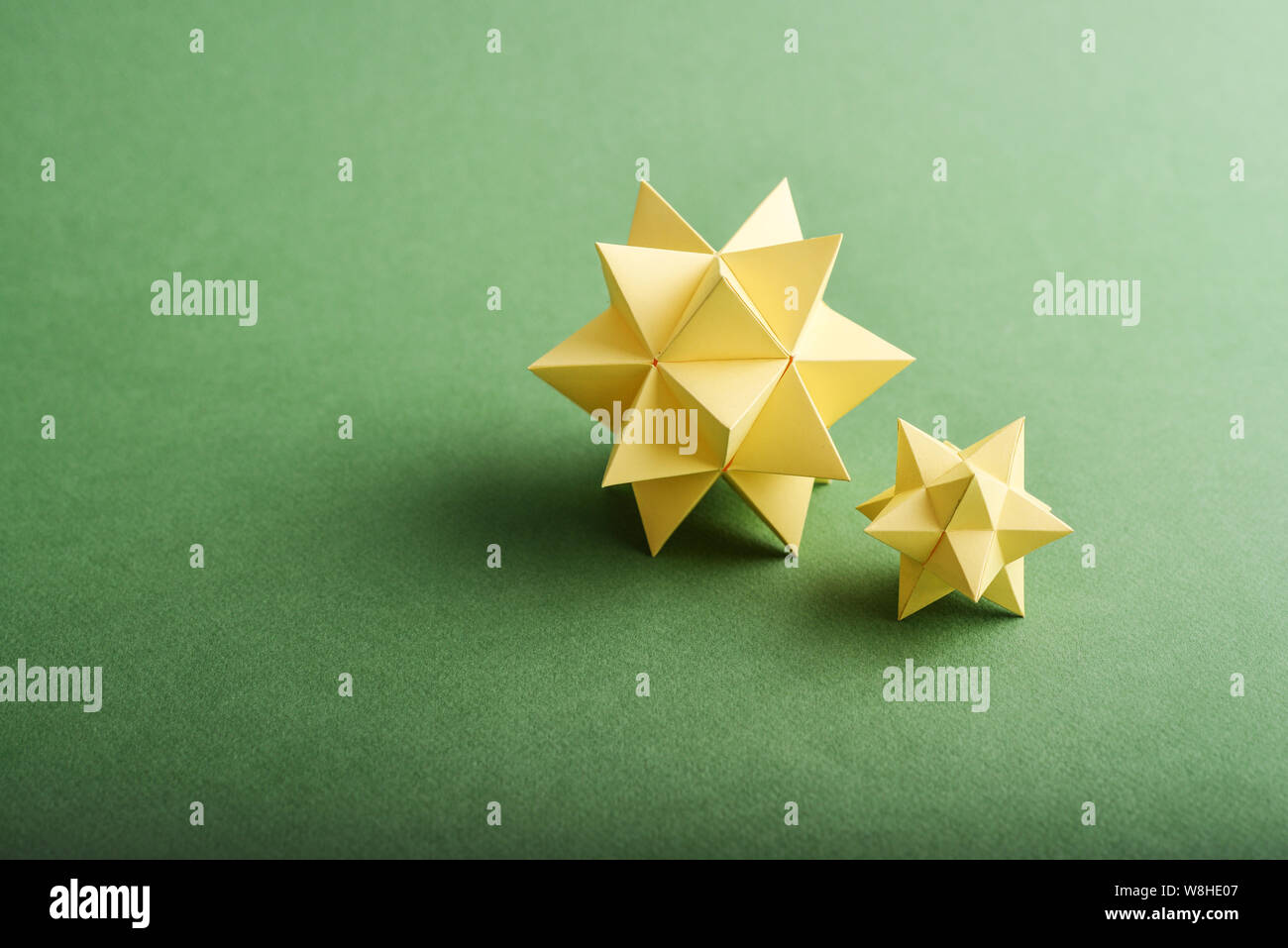 Two handmade yellow paper polyhedrons on a green background Stock Photo ...