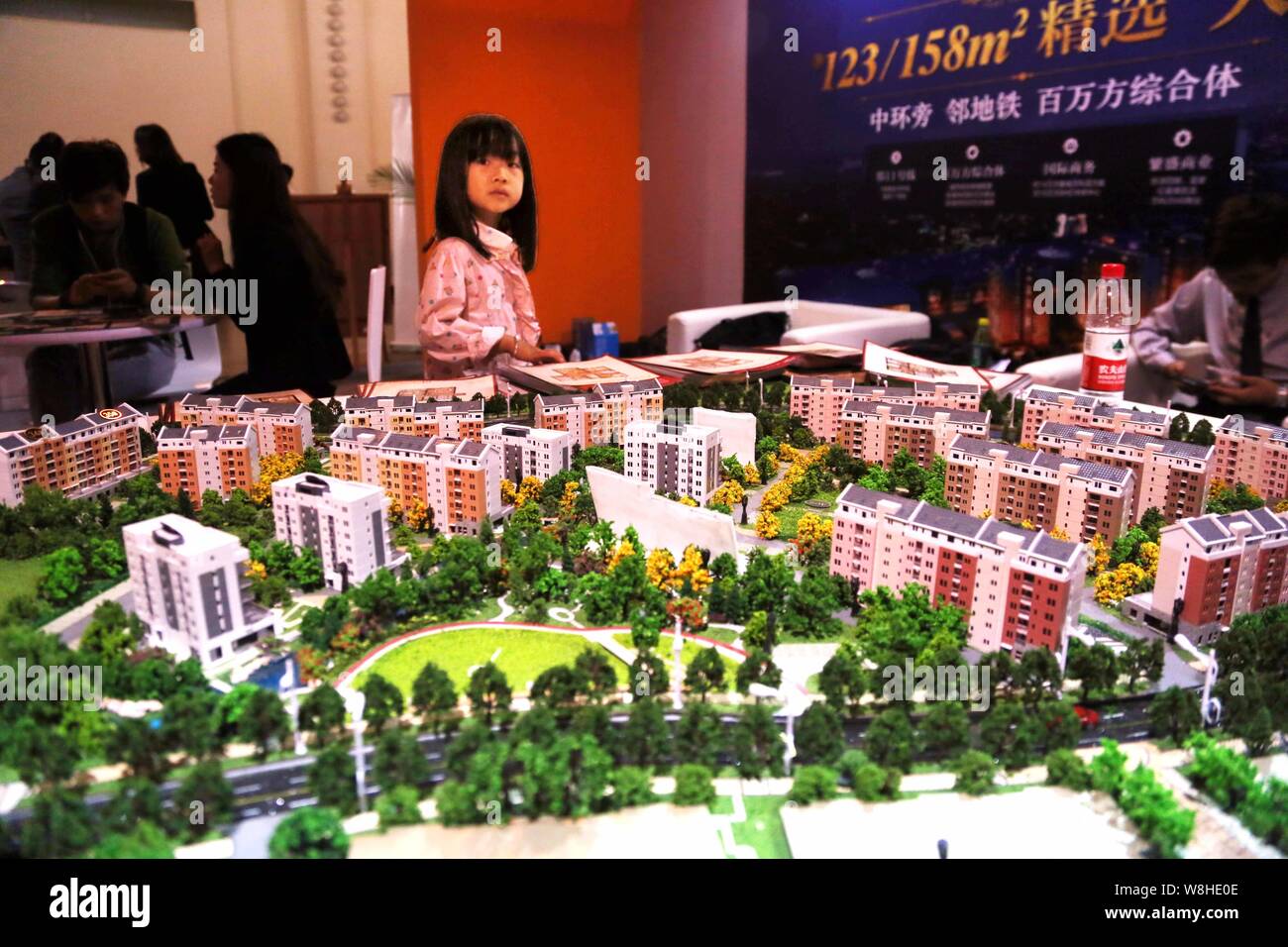 --FILE--A young Chinese girl looks at housing models of a residential ...