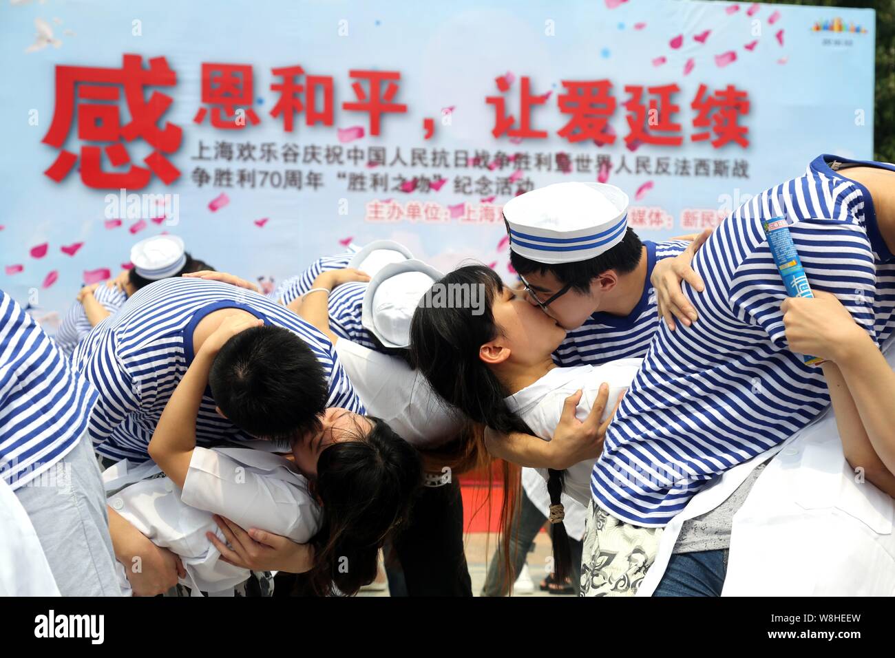 Couples of young Chinese lovers kiss to imitate the "Victory Kiss" at a ...