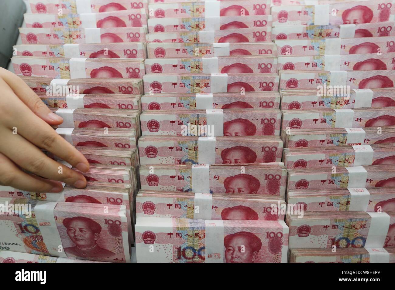 --FILE--A Chinese clerk counts RMB (renminbi) yuan banknotes at a bank ...