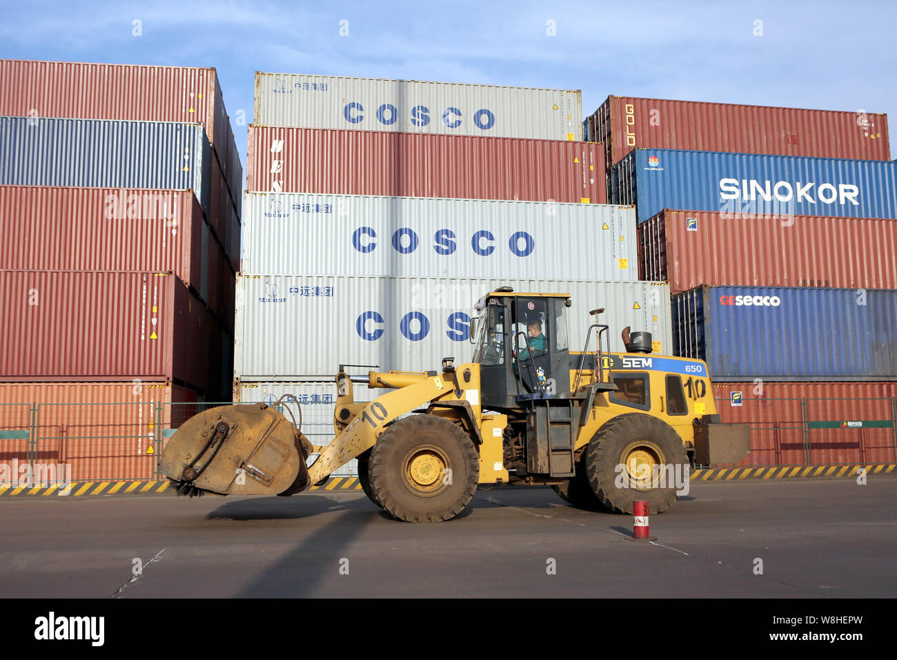 --FILE--A wheel loader passes by stacks of containers of Cosco and ...