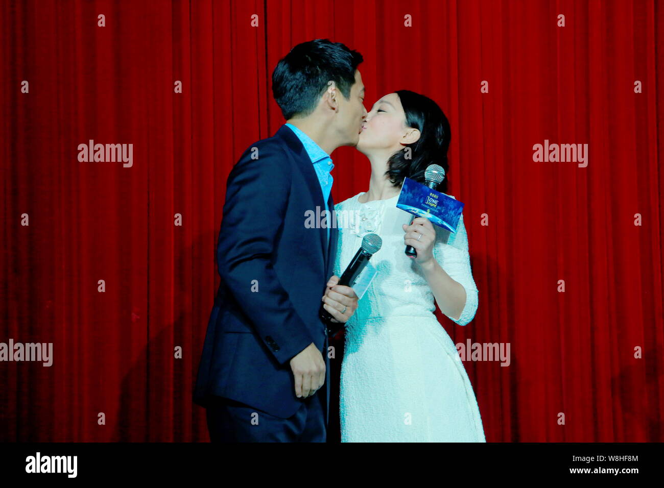 Chinese actress Zhou Xun and her American actor husband Archie Kao kiss ...