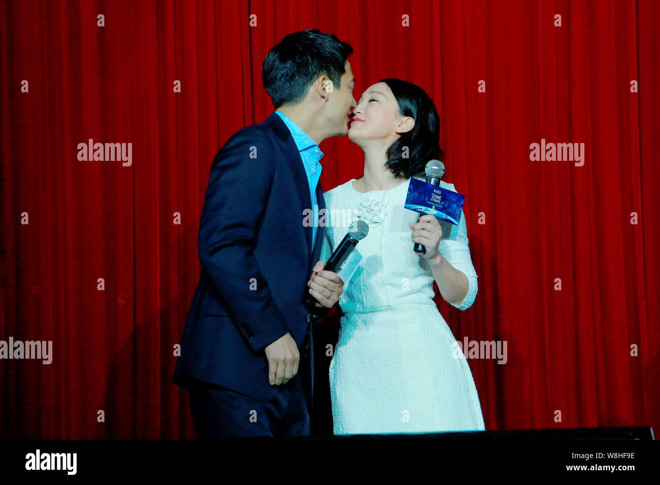 Chinese actress Zhou Xun and her American actor husband Archie Kao kiss ...