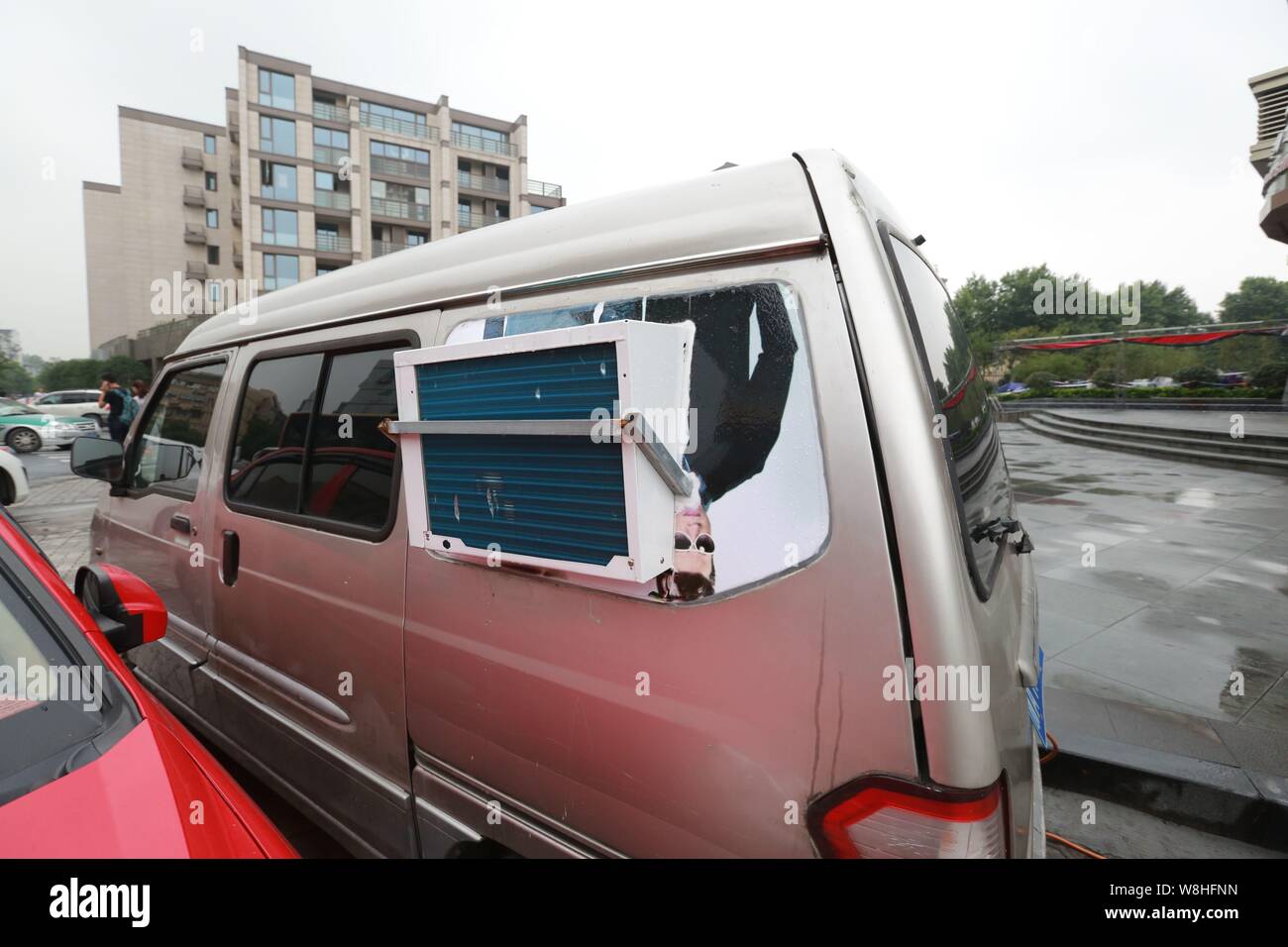 View of a mini-van with an air conditioning unit installed on its left ...