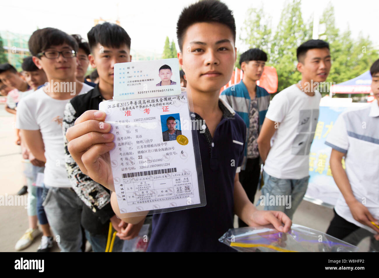 A Chinese student displays his admission card and identity card before ...