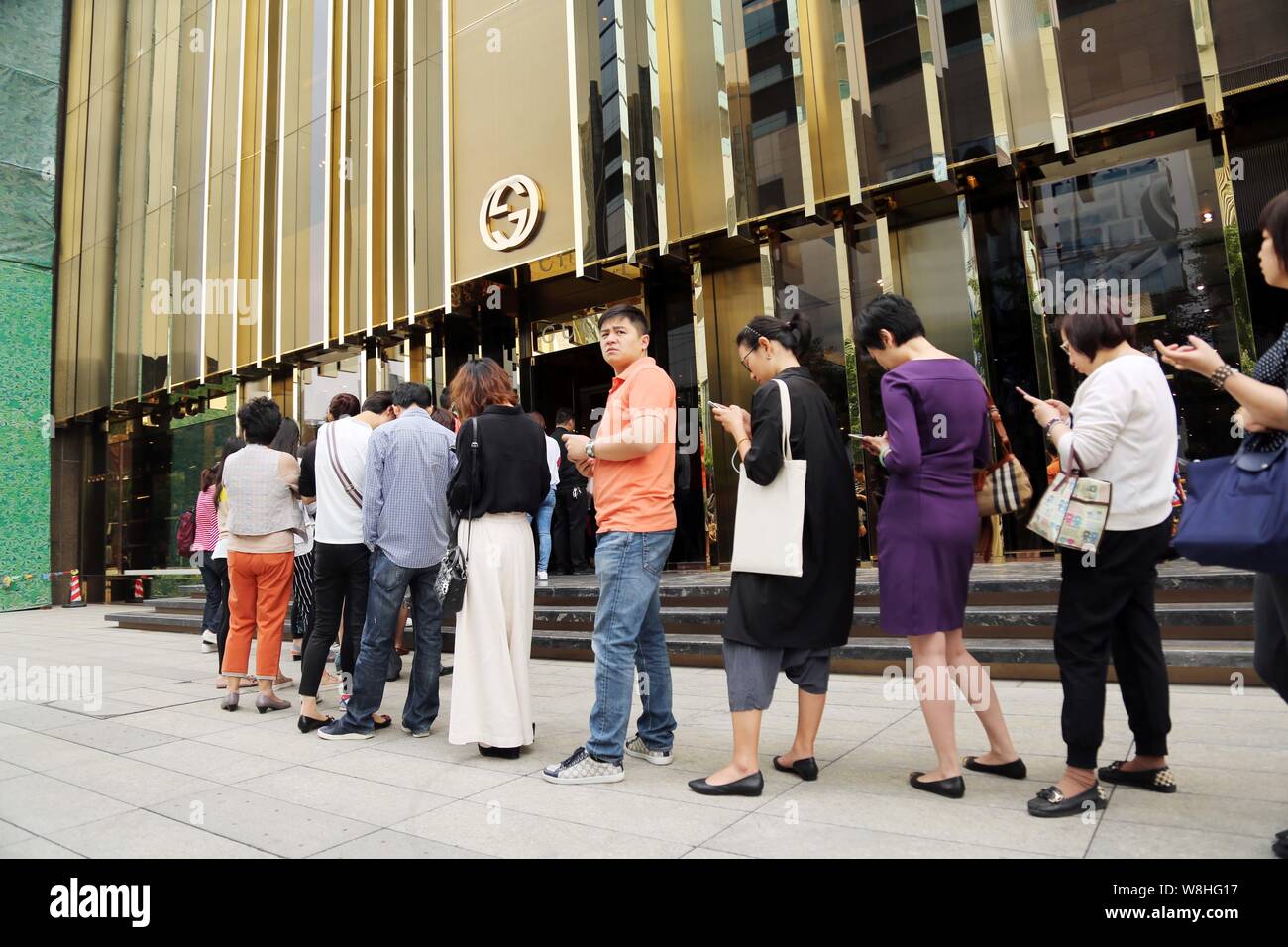 Customers queue up in front of a Gucci store at a shopping mall in ...