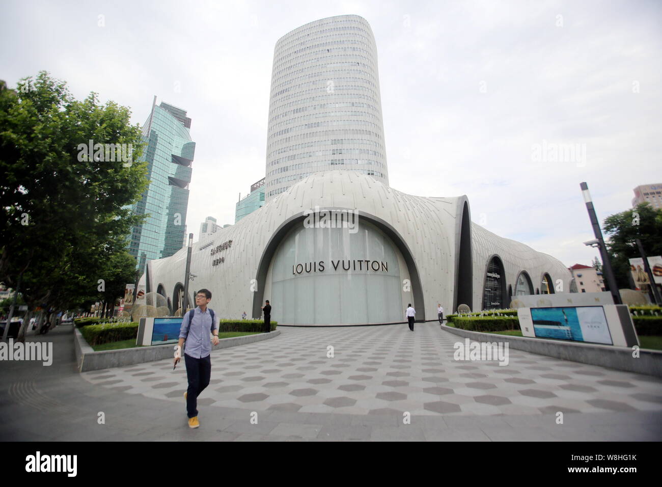 Pedestrians walk past the fashion boutique of Louis Vuitton at L'Avenue ...