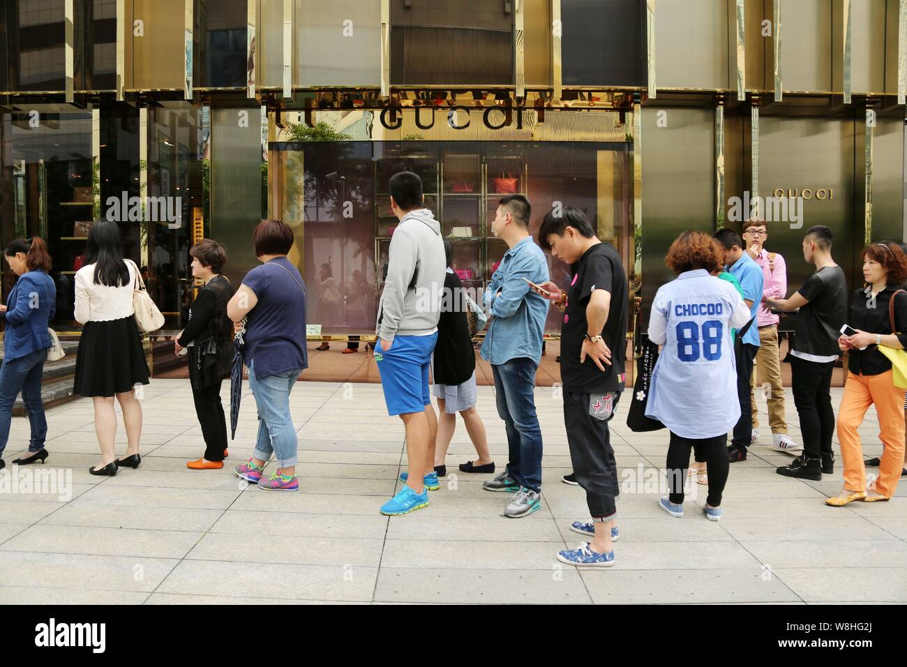 Customers queue up in front of a Gucci store at a shopping mall in ...