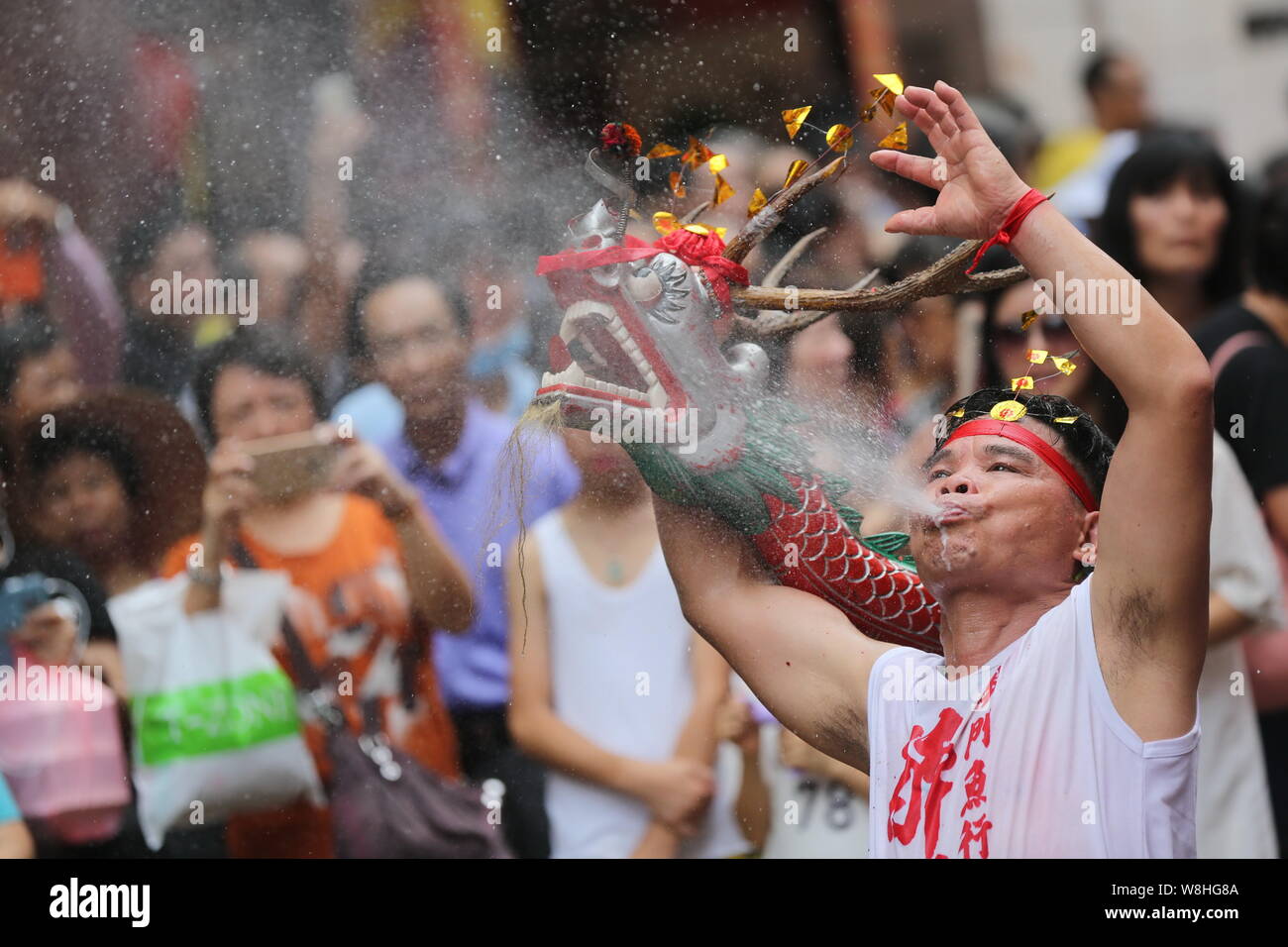 A performer sprays beer from his mouth to perform a drunken dragon ...