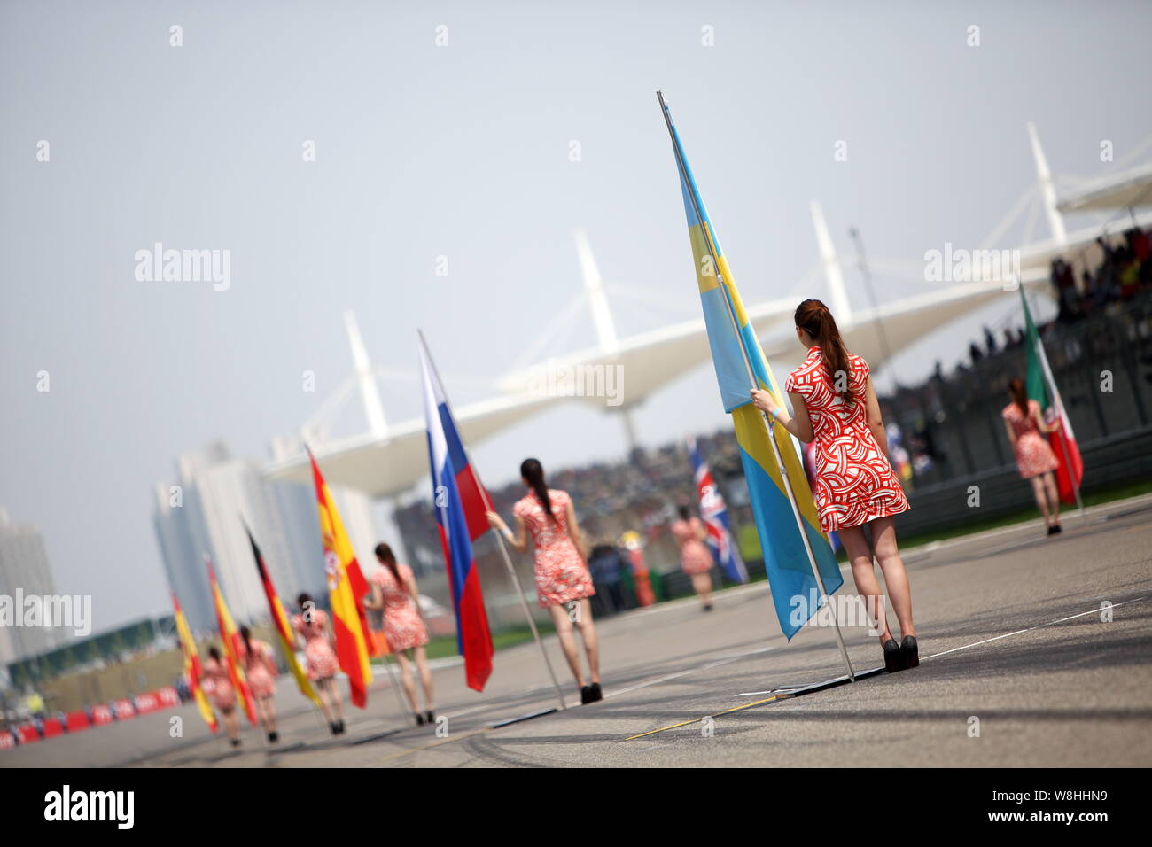 Hostesses pose with national flags on the track ahead of the 2015 ...