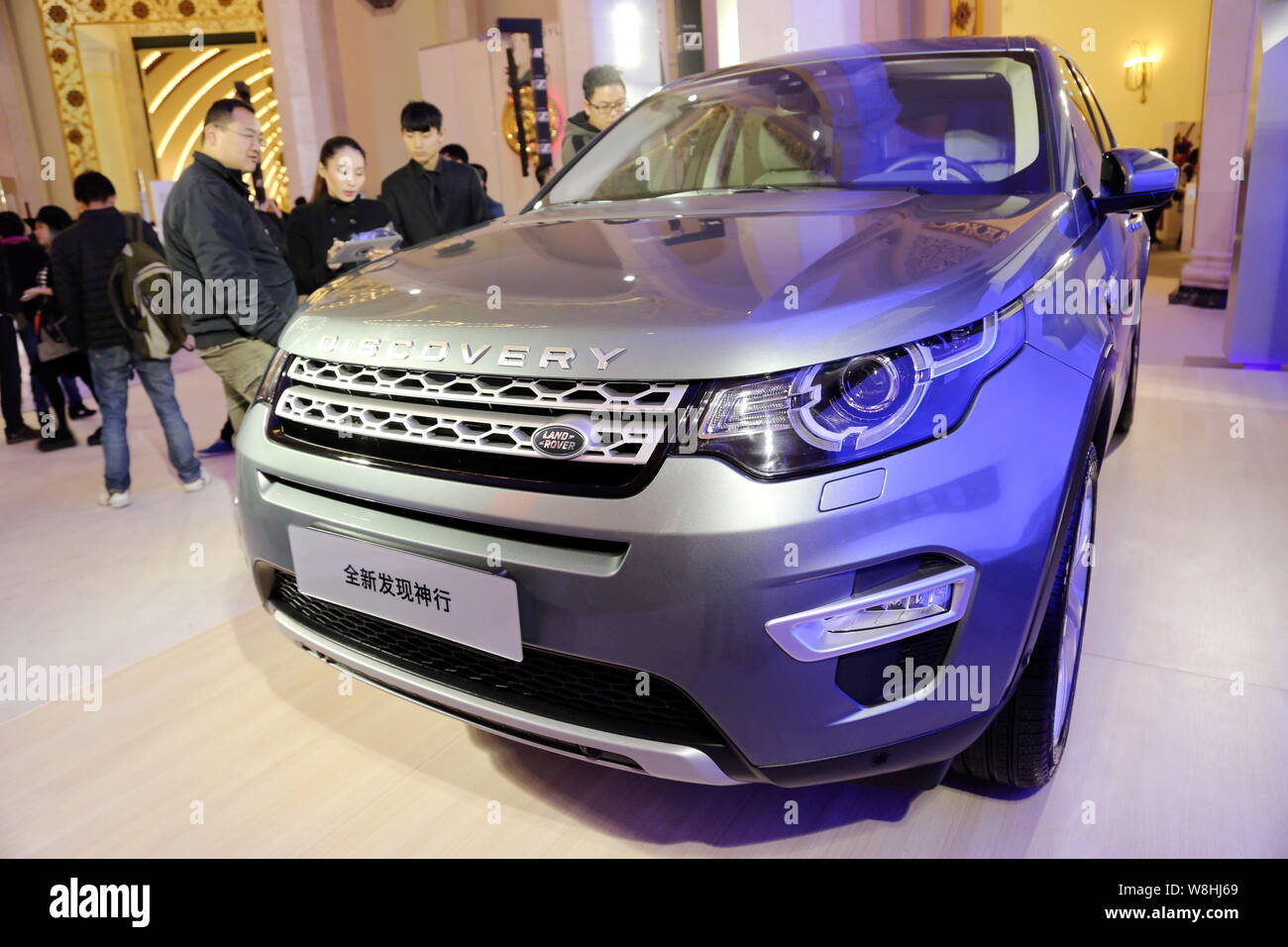 --FILE--Visitors look at a Land Rover Discovery on display during an ...