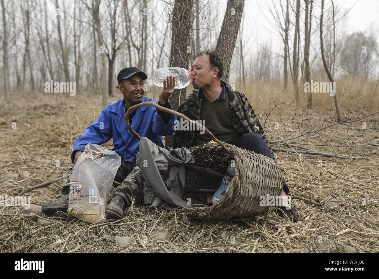 Blind Chinese man Jia Haixia, left, holds a bottle to help his armless ...