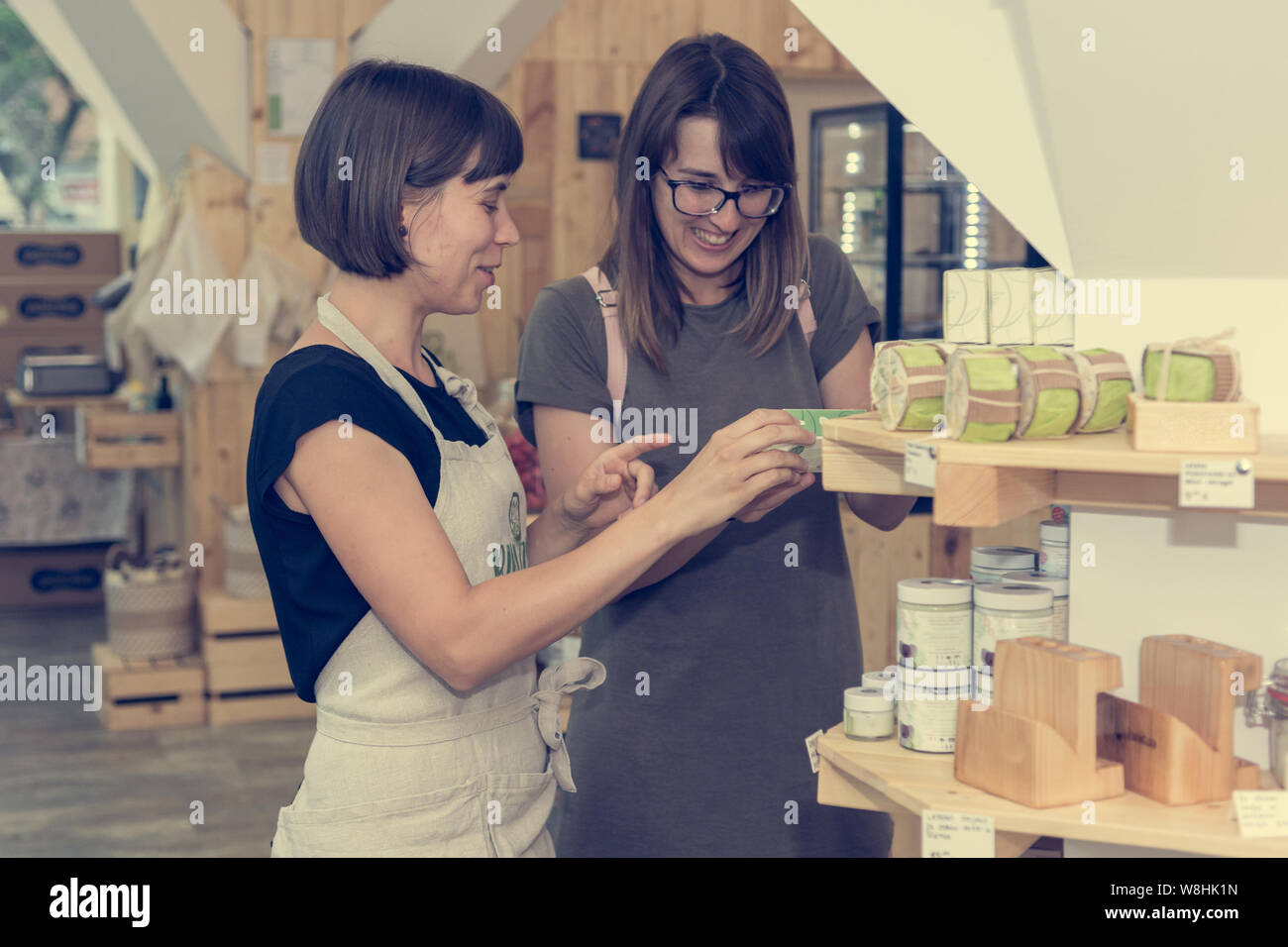 Female shopkeeper helping a customer in zero waste store Stock Photo ...