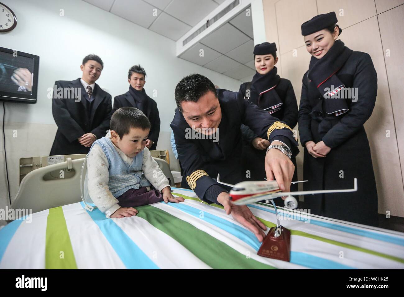 A Chinese pilot of China Eastern Airlines, center, gives a model plane ...