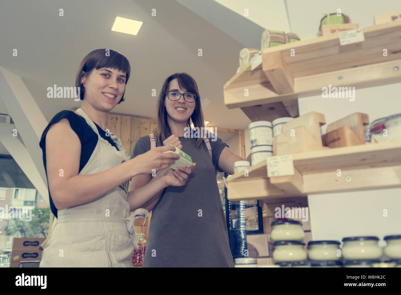 Female shopkeeper helping a customer in zero waste store Stock Photo ...