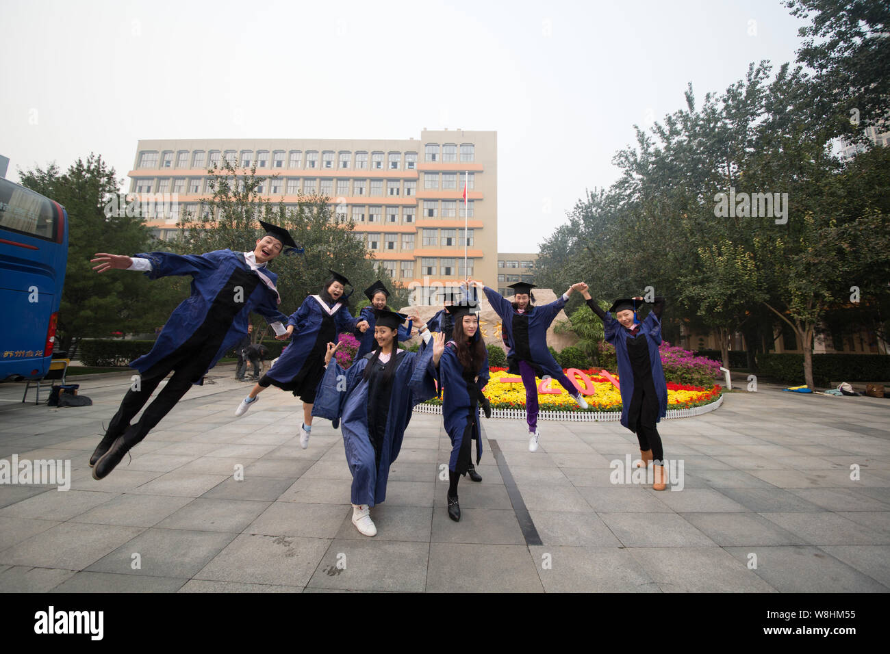 Chinese graduates dressed in academic gowns pose for graduation photos ...