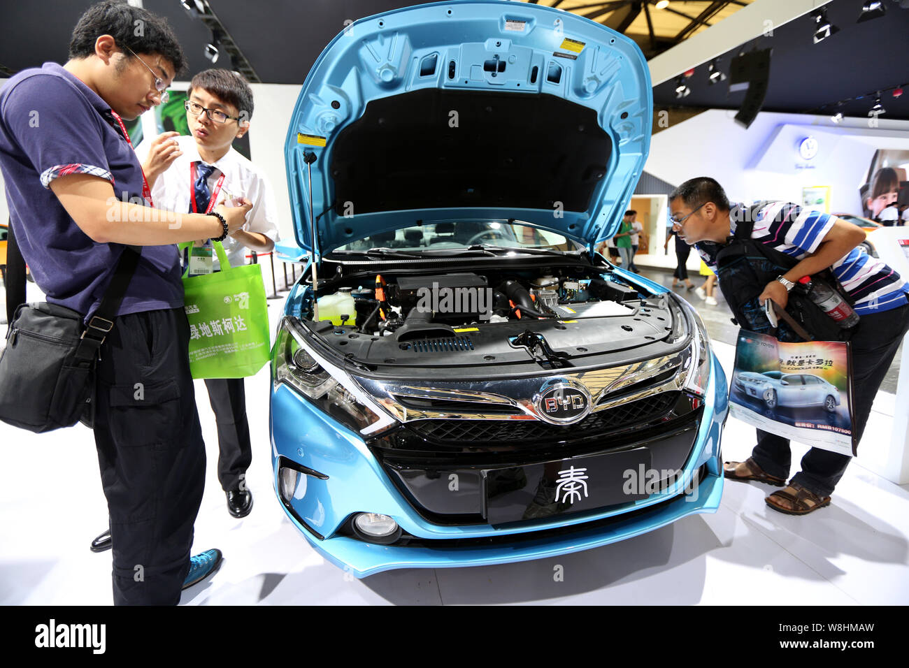 --FILE--Visitors look at a BYD Qin hybrid car on display during the ...
