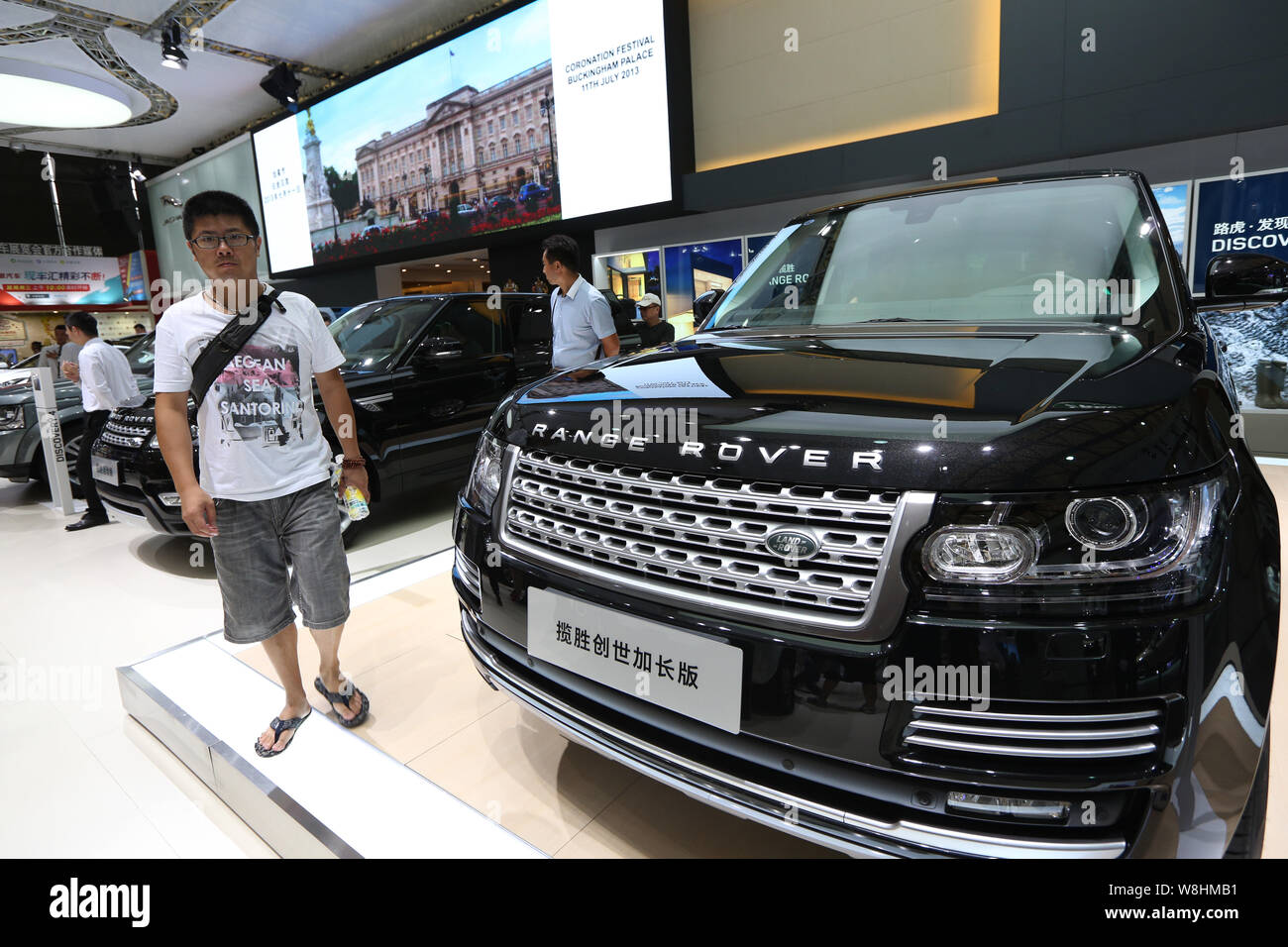 --FILE--A visitor poses next to a Range Rover of Jaguar Land Rover on ...