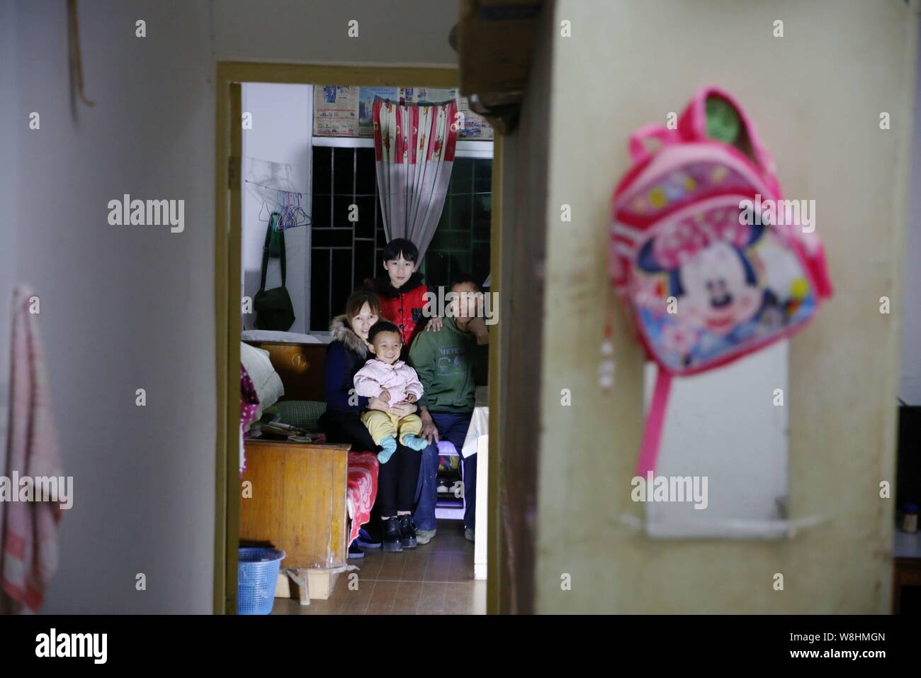 Eight-year-old girl Kuang Yahui, front, poses with her family at home ...