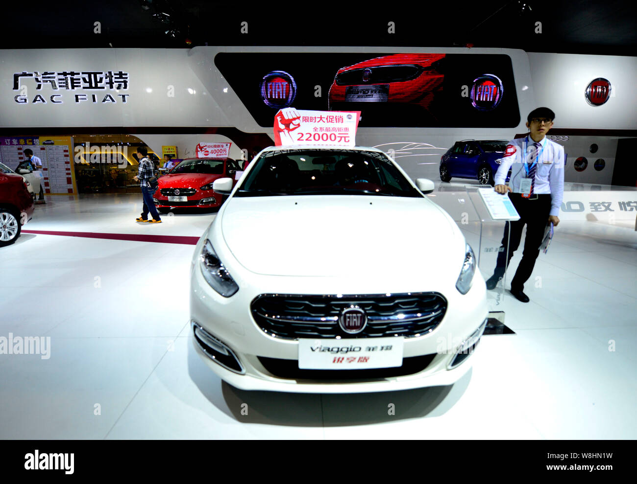 --FILE--A Chinese employee stands next to a Fiat Viaggio of GAC Fiat ...