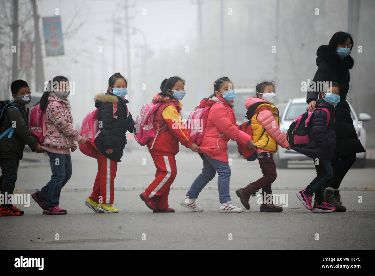 Chinese pupils and their teacher wearing face masks against air ...