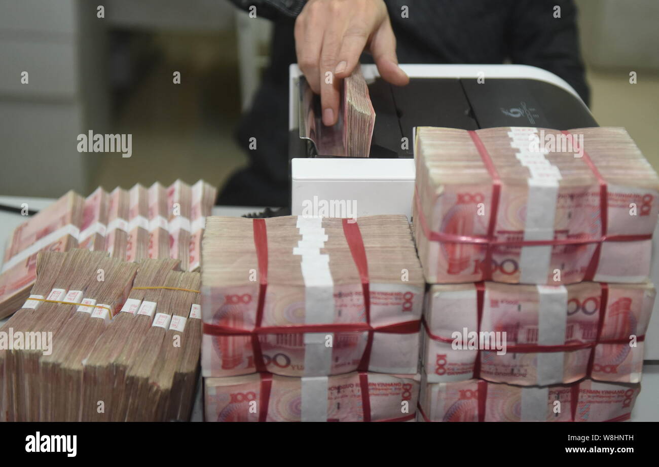 --FILE--A Chinese clerk uses a cash-counting machine to count RMB ...
