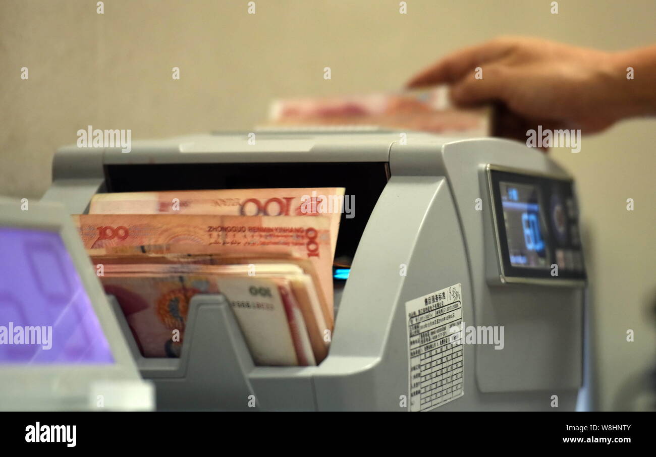 --FILE--A Chinese clerk uses a cash-counting machine to count RMB ...