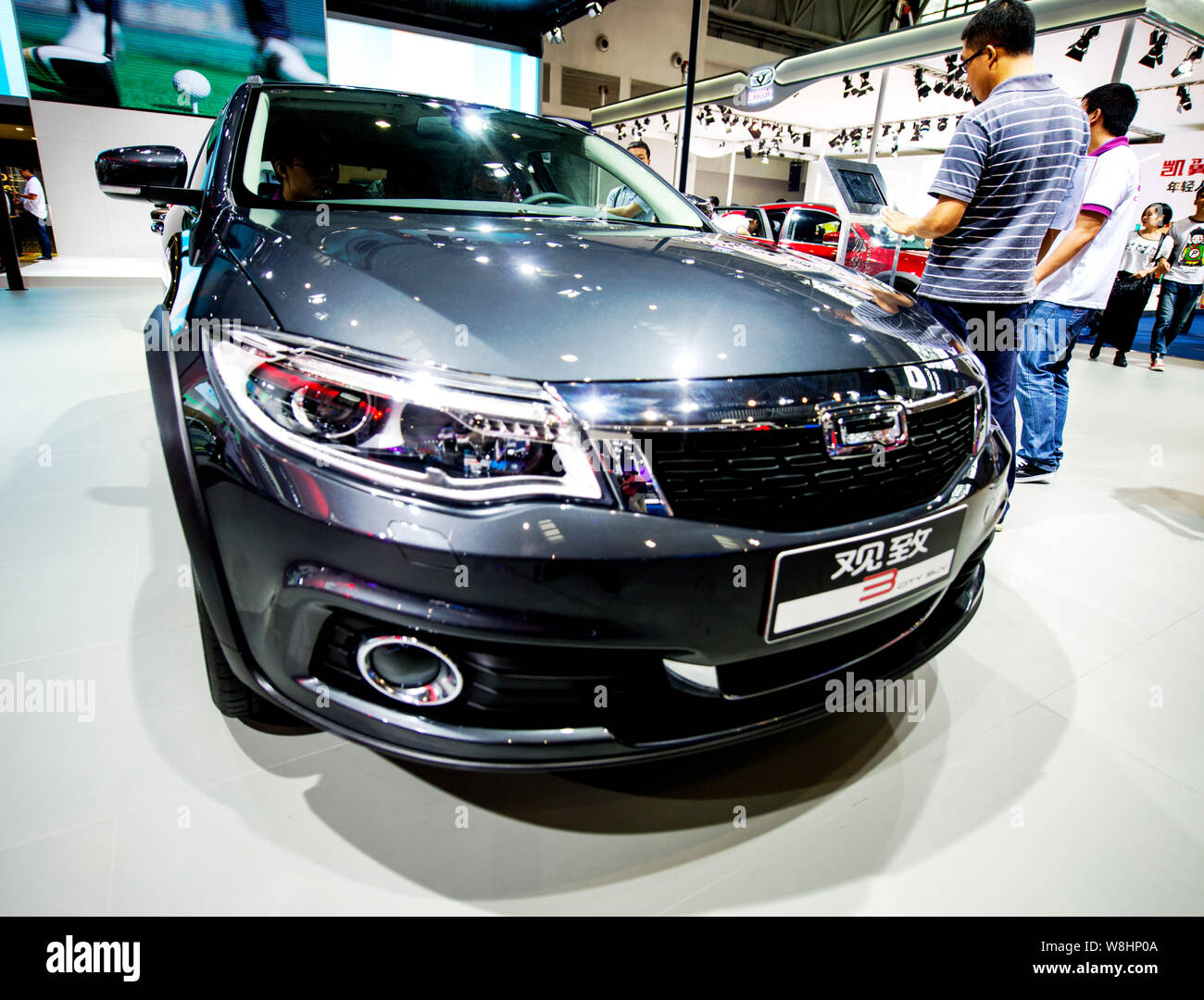 --FILE--Visitors look at a Qoros 3 during an auto show in Chongqing ...