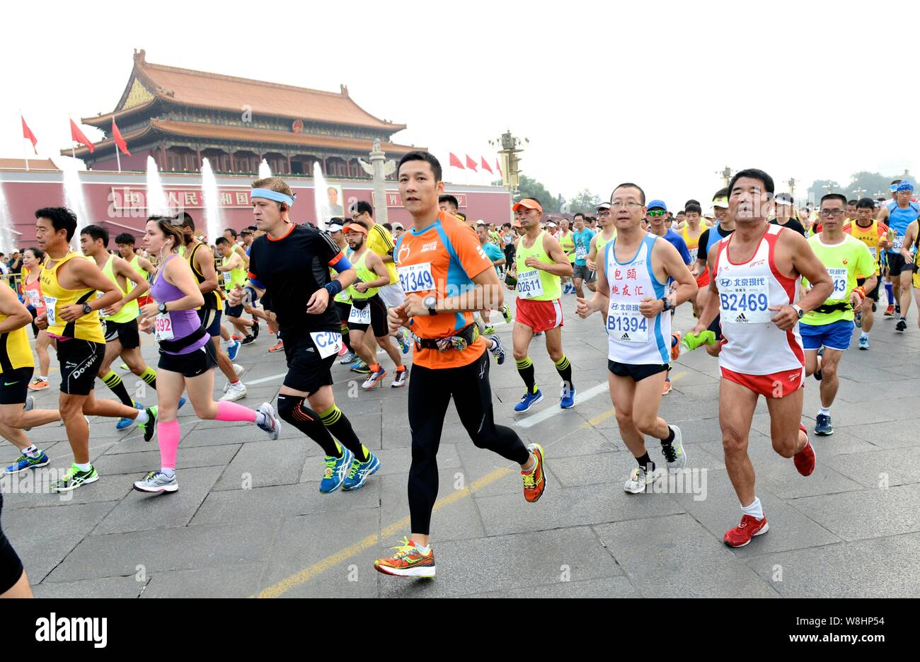 Chinese and foreign participants run past the Tian'anmen Rostrum during ...
