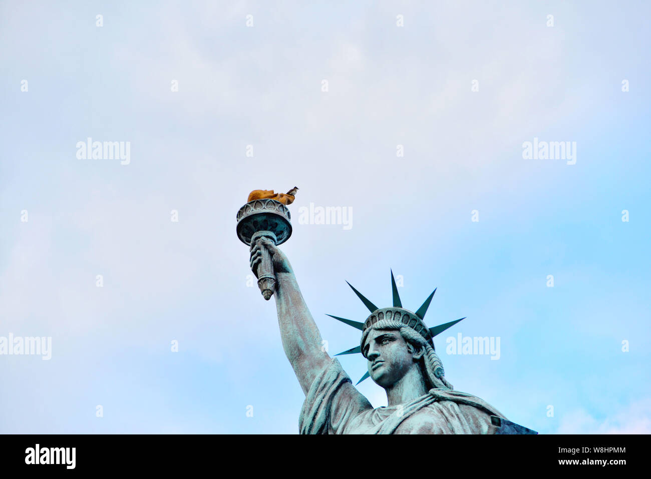 A bird stands atop a downsized replica of the Statue of Liberty in the ...