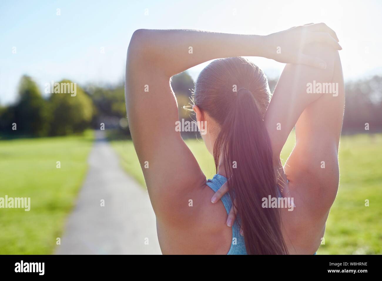 Young woman stretching arm, rear view Stock Photo - Alamy