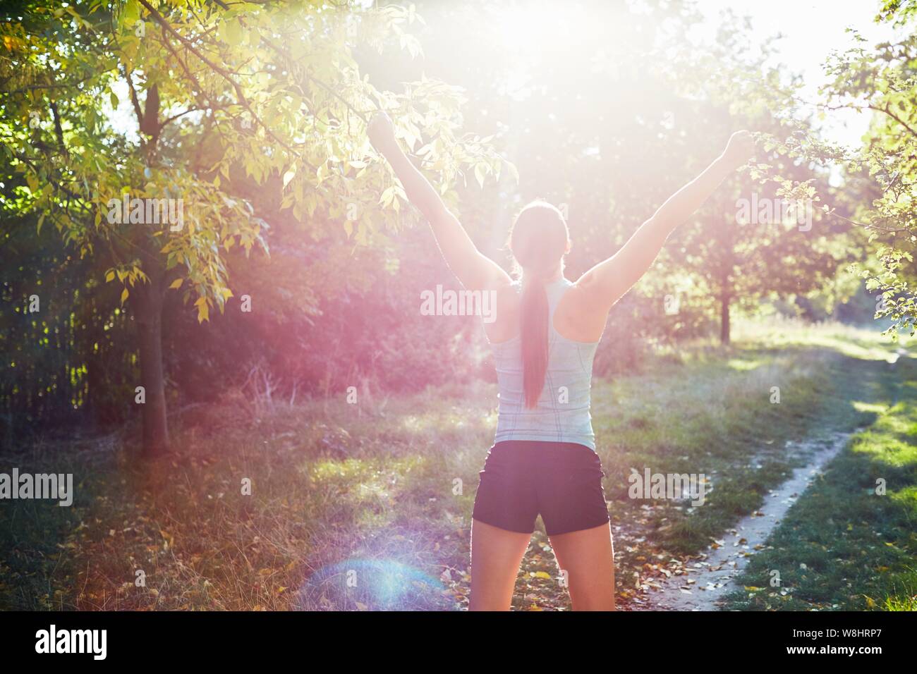 Young woman arms outstretched rear hi-res stock photography and images ...