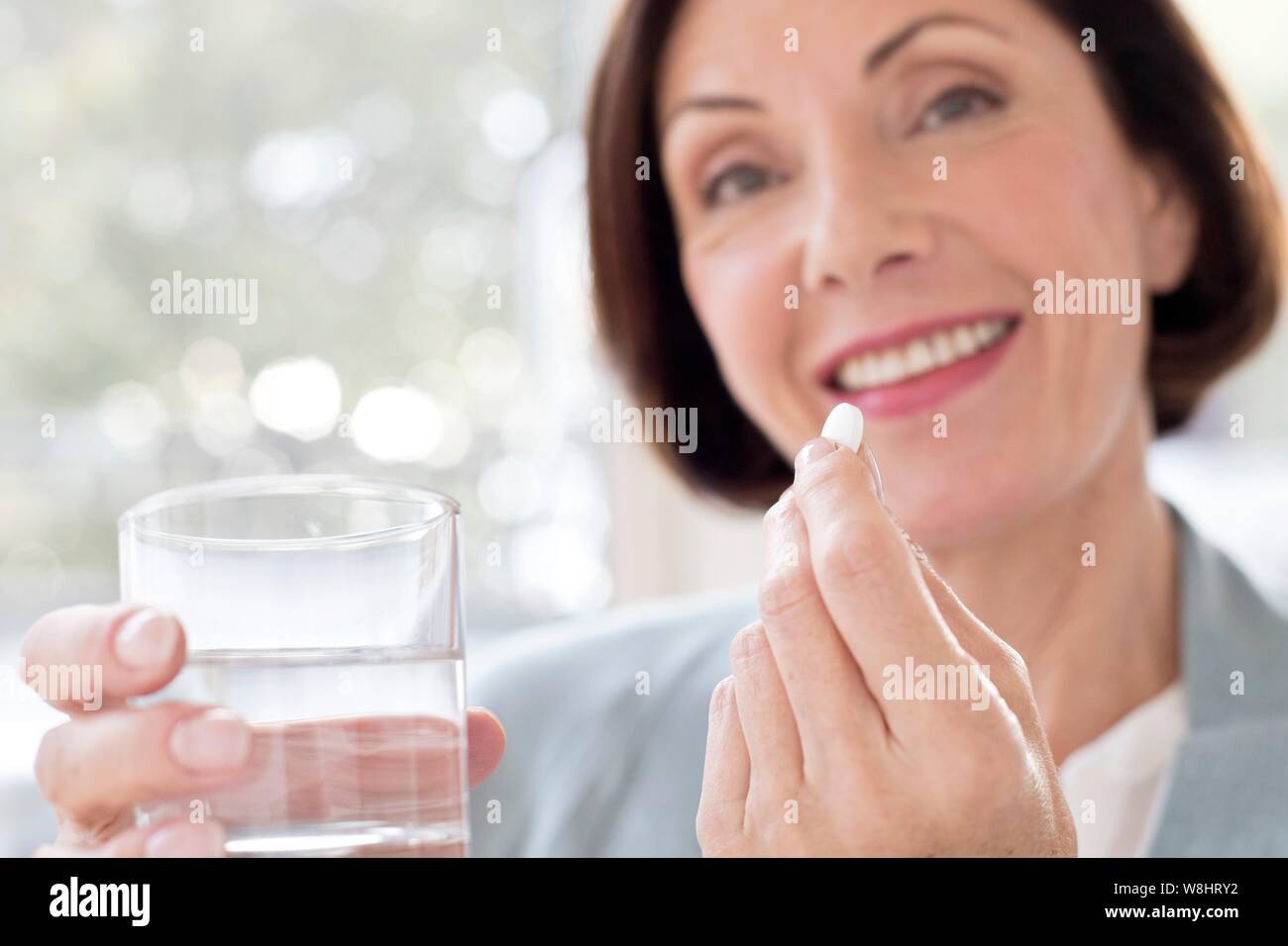 Mature woman taking tablet Stock Photo - Alamy
