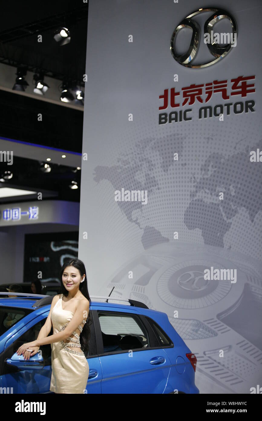 --FILE--A showgirl poses with a car at a stand of China BAIC Motor ...