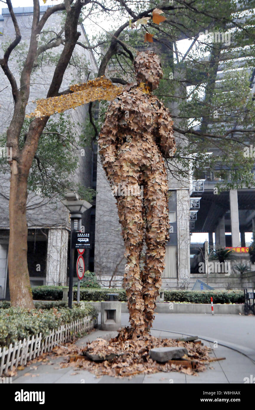 A giant-man-shaped artwork made of fallen leaves is pictured in front ...