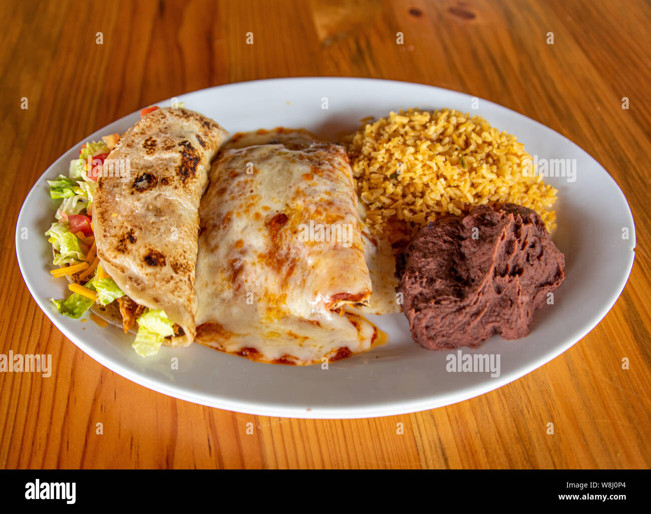 Chicken Enchilada plate with rice, beans and chicken taco Stock Photo ...
